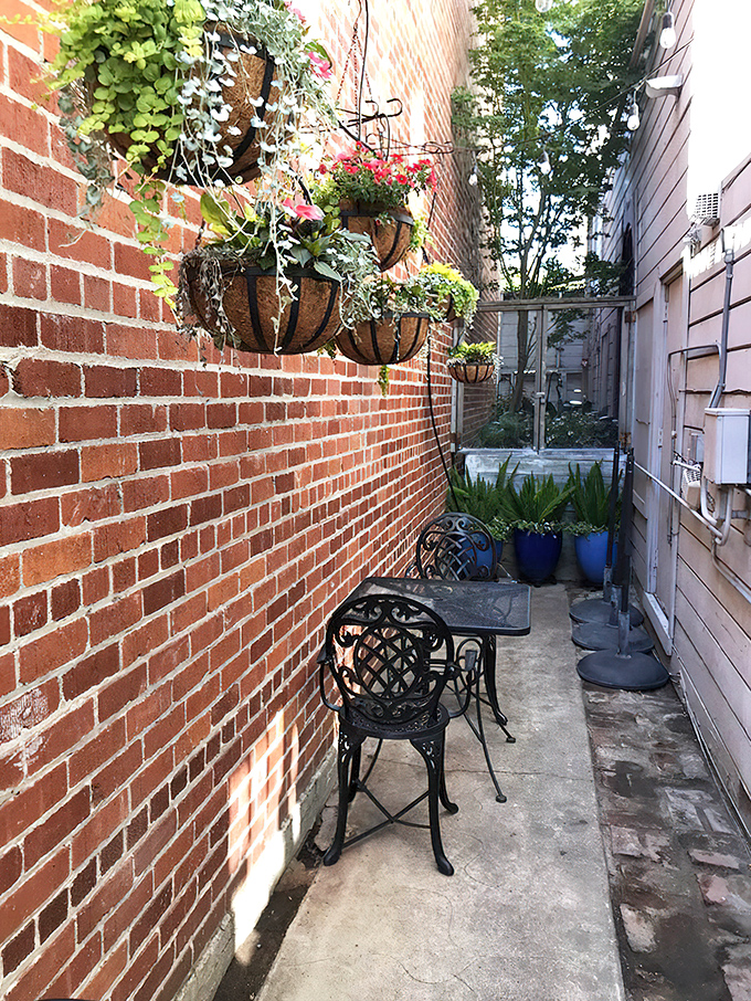 The secret courtyard offers a brick-walled sanctuary for intimate conversations or solo dining adventures away from Main Street's hustle.