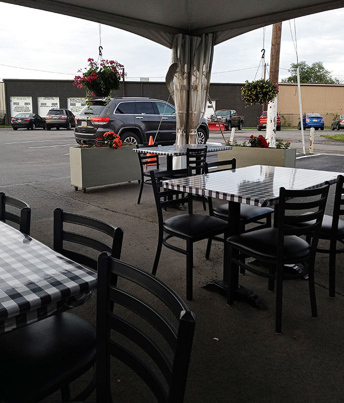 Outdoor seating adorned with hanging flowers adds a touch of charm. Even al fresco, those signature checkered tablecloths maintain the Glider's classic aesthetic. 