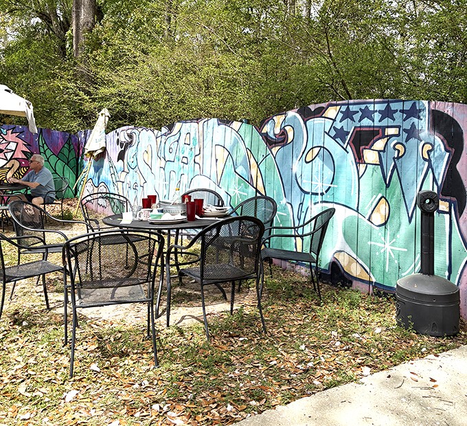 Outdoor seating against a backdrop of colorful murals offers a perfect spot for morning philosophers and coffee contemplators alike.