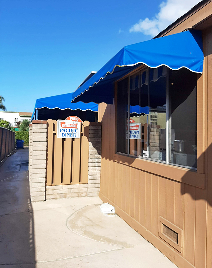 The patio entrance beckons with its wooden gate and signature blue awning&mdash;a portal to comfort food paradise.