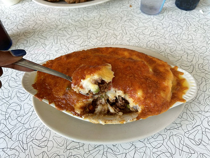 Beneath that golden crust lies a savory treasure of seasoned beef and vegetables&mdash;comfort food archaeology at its most delicious.