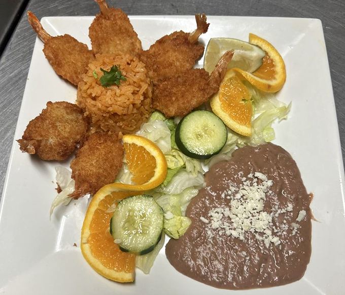 Fried shrimp arranged like a golden crown around orange slices and rice—seafood royalty that deserves your full attention.