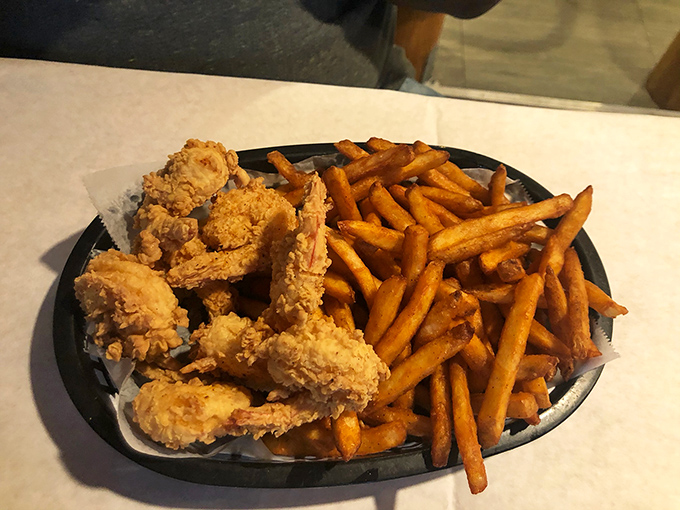 Golden-fried shrimp nestled against perfectly seasoned fries – comfort food that somehow manages to feel like a special occasion.