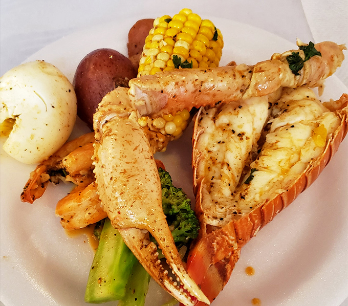 A plate that looks like it was composed by a seafood symphony conductor—lobster, shrimp, and corn in perfect harmony with potatoes playing backup.