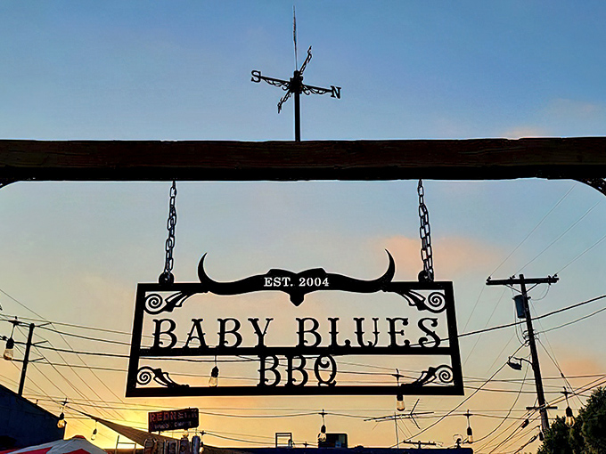 The hanging sign against a sunset sky announces "EST. 2004" – relatively young in barbecue years but wise beyond its age.