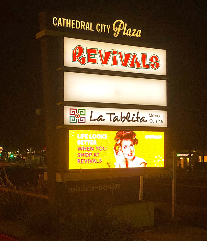 Even at night, Revivals' sign shines like a beacon for bargain hunters – "Life looks better when you shop at Revivals" is no exaggeration.