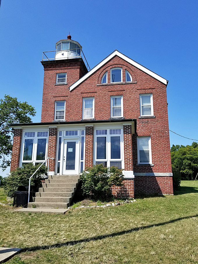South Bass Island Lighthouse stands guard like a brick sentinel with windows, watching over mariners since 1897 with steadfast architectural dignity.