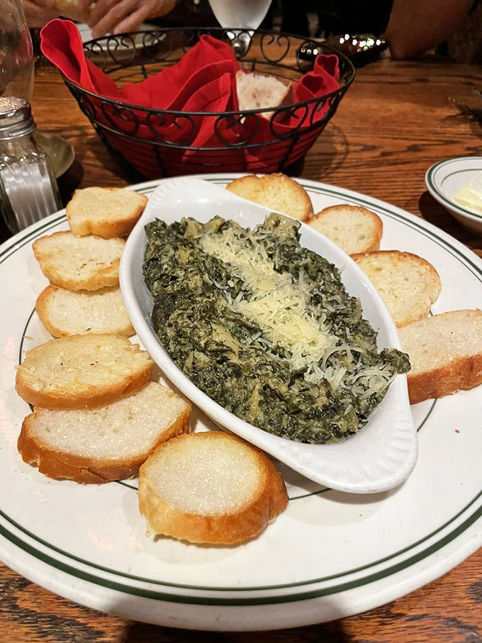 The spinach artichoke dip arrives surrounded by toasted bread like courtiers attending a queen&mdash;rich, indulgent, and impossible to resist.