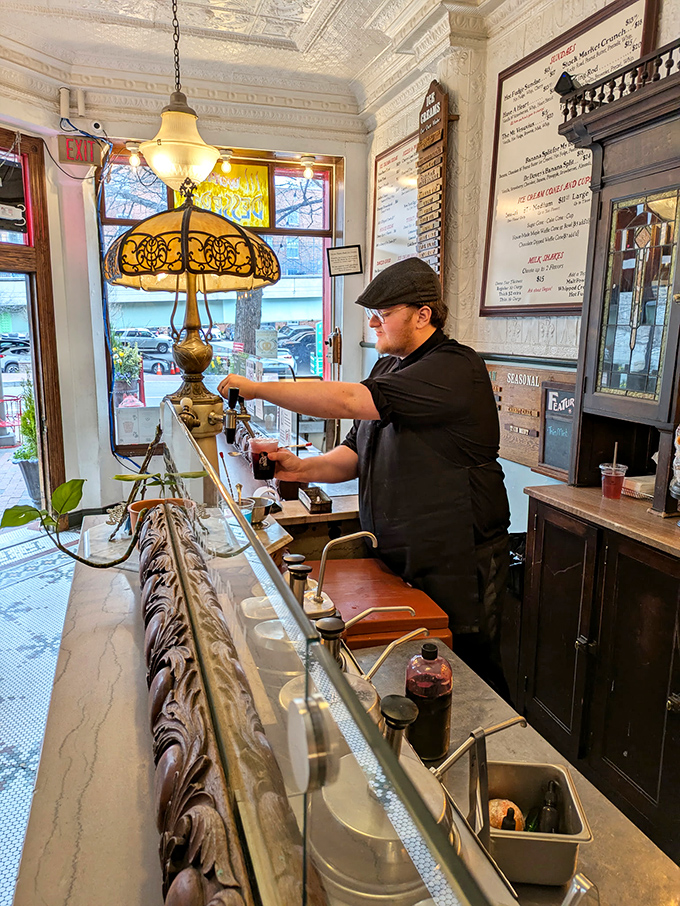 Master craftspeople work their frozen magic with tools and techniques that honor soda fountain traditions spanning generations.