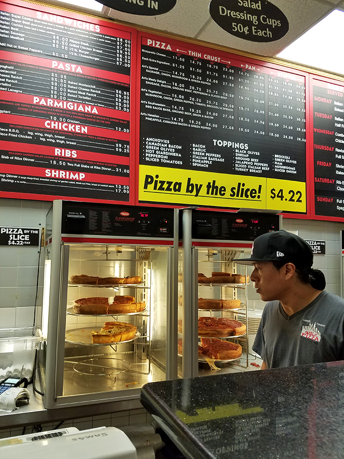 Behind every great pizza is someone who understands that food is both science and soul. The display case showcases edible masterpieces awaiting adoption.