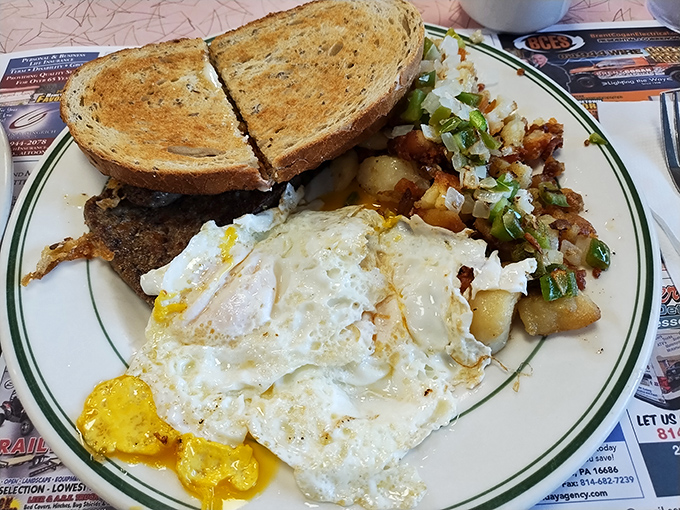 The holy trinity of breakfast: perfectly fried eggs, home fries with just the right crisp, and toast ready for its butter close-up.