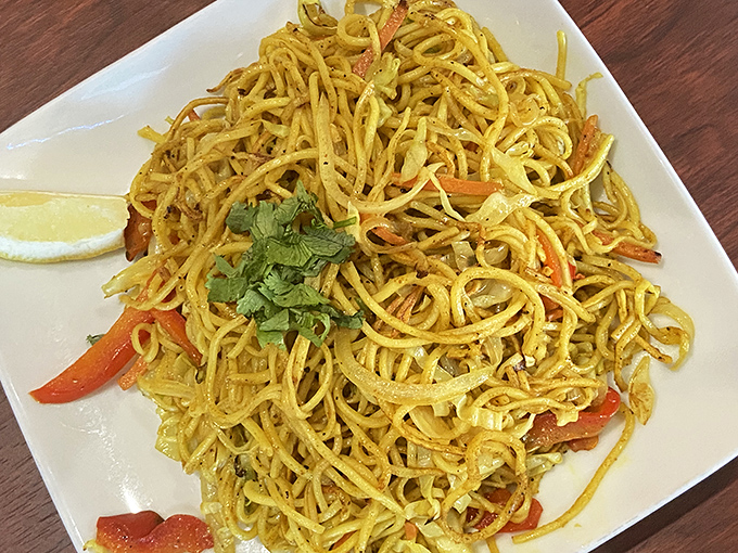 These stir-fried noodles aren't just a dish—they're a tangle of spice-kissed strands topped with fresh cilantro that bridges continents on a single plate.