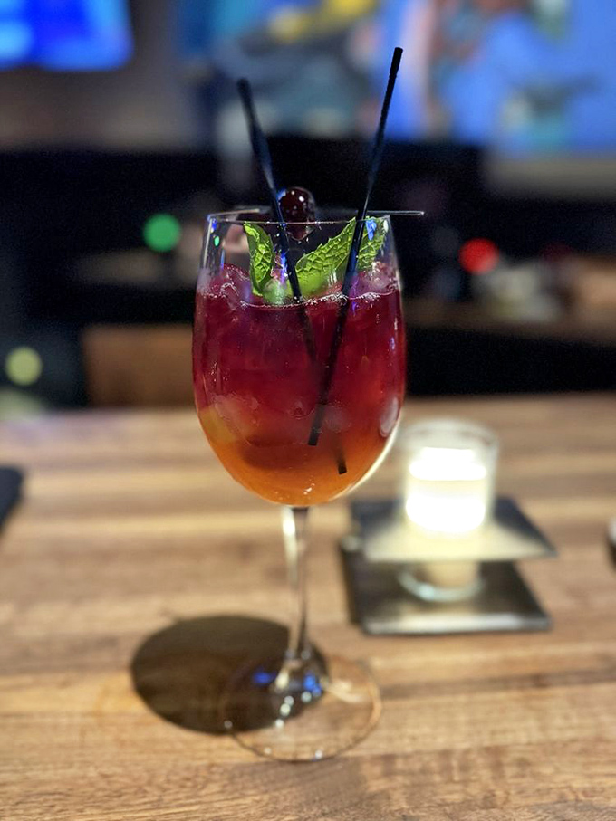 This sangria looks like a sunset decided to retire into a wine glass. Those mint leaves are just showing off now.