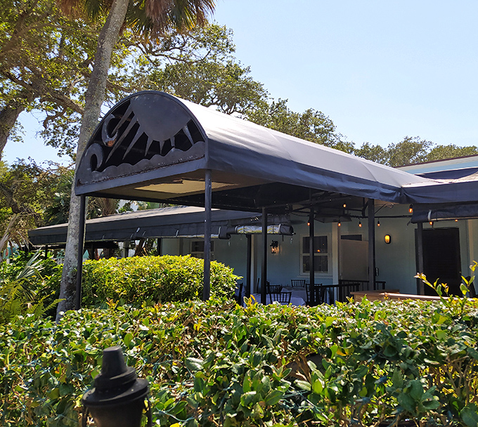 The Tides Restaurant's elegant awning promises shelter from the sun but not from culinary temptation. Ocean breezes included with every reservation.