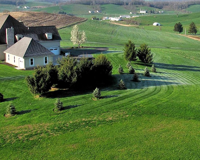 Freshly mowed lawns surround this country home, where the landscaping is so precise it makes suburban lawn enthusiasts weep with envy.