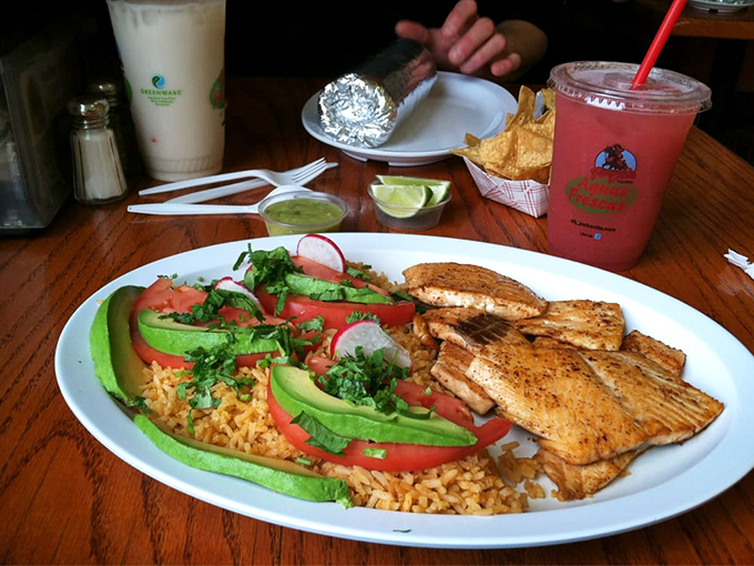 A feast fit for coastal royalty: perfectly grilled fish, vibrant rice, and fresh garnishes that transport you to a beachside cabana.