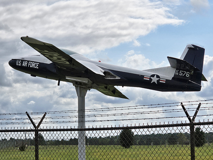 A sleek reconnaissance aircraft mounted as if frozen mid-mission, still looking like it's hunting secrets from behind the fence.