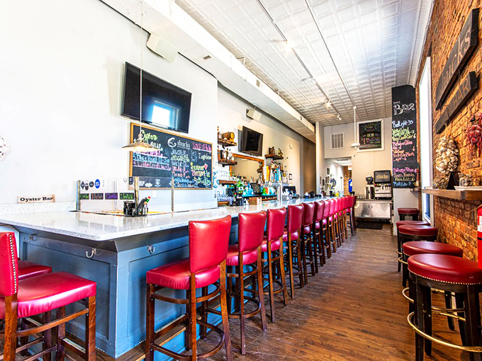 The bar area&mdash;where strangers become friends over craft beers and oyster stories. Red stools invite you to stay "just one more round."