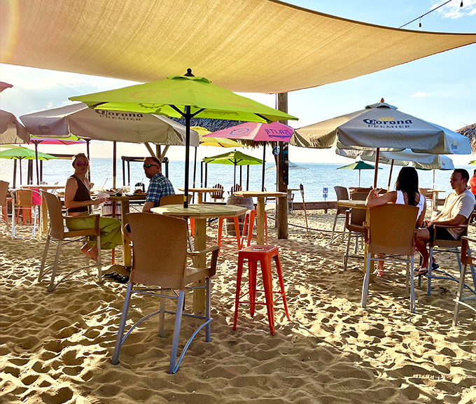 Beach umbrellas, cold drinks, and tables in the sand – the kind of dining setup that makes Monday meetings seem very far away.