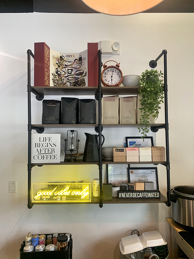 "Life begins after coffee" proclaims the shelf d&eacute;cor, while the neon "good vibes only" sign below makes a compelling argument for morning optimism.