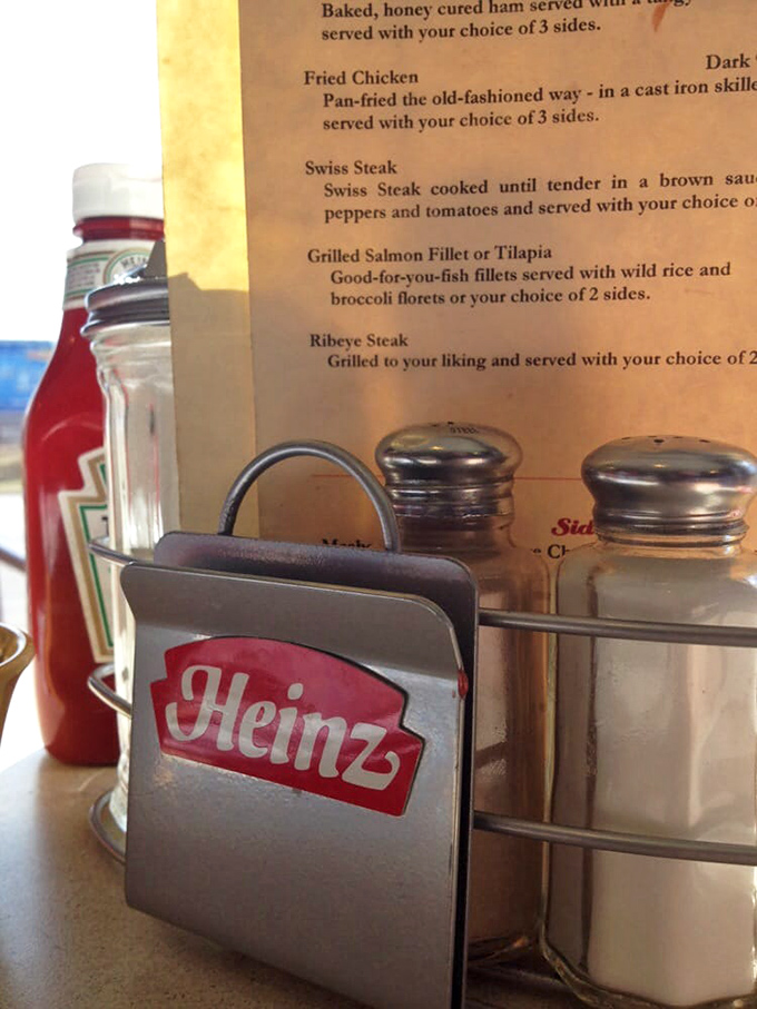 The holy trinity of diner condiments&mdash;ketchup, salt, and pepper&mdash;standing guard beside a menu that promises fried chicken "pan-fried the old-fashioned way." 