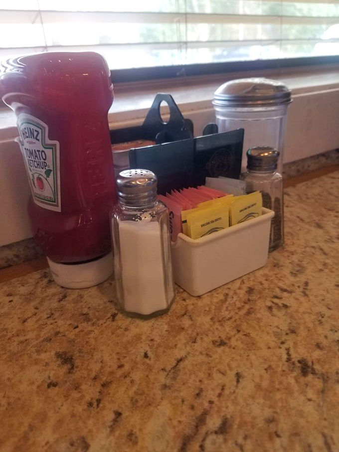 The condiment caddy—civilization's greatest achievement. Salt, pepper, sugar packets, and ketchup bottles that never quite empty completely.