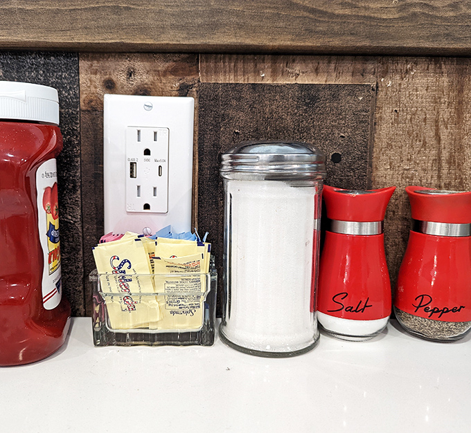 The condiment station &ndash; salt, pepper, and sweetener packets arranged with the precision of a NASA launch sequence.