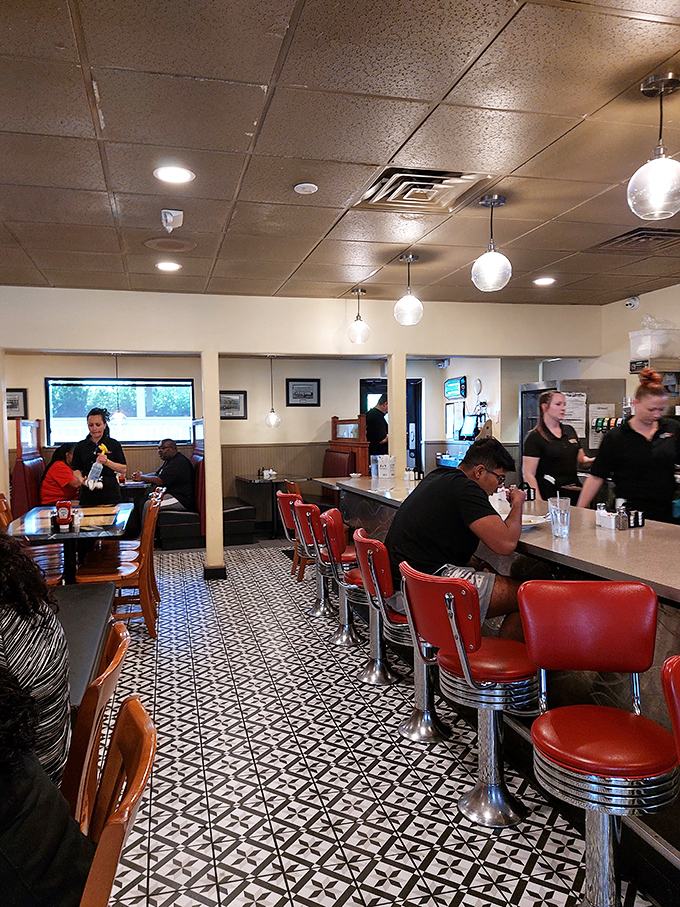 The counter seating offers front-row tickets to the breakfast ballet, where red vinyl stools spin and servers perform the dance of plates and coffee refills.