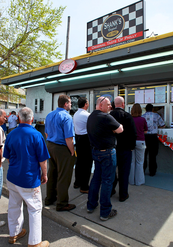 The line forms early and with purpose. These patient pilgrims know that greatness awaits at the window. 