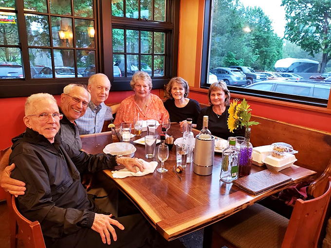 Happy diners gathered around the table &ndash; proof that great food creates the best memories.