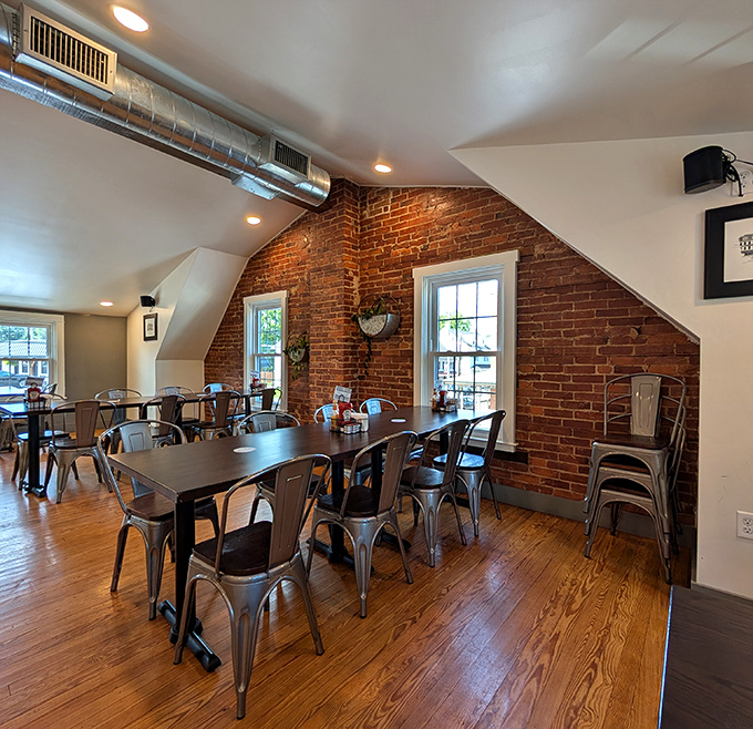 Exposed brick meets modern industrial in this upstairs dining area where metal chairs and wooden tables create the perfect breakfast backdrop.