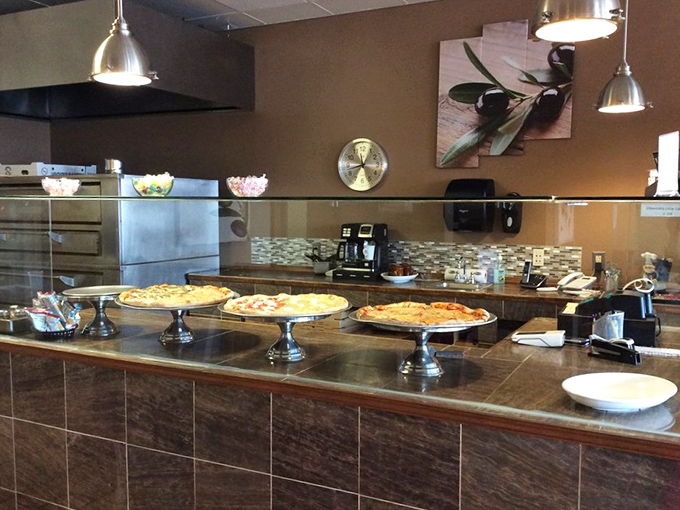 Pizza perfection on display – these pies await their destiny on silver pedestals, each a testament to the art of dough, sauce and cheese.