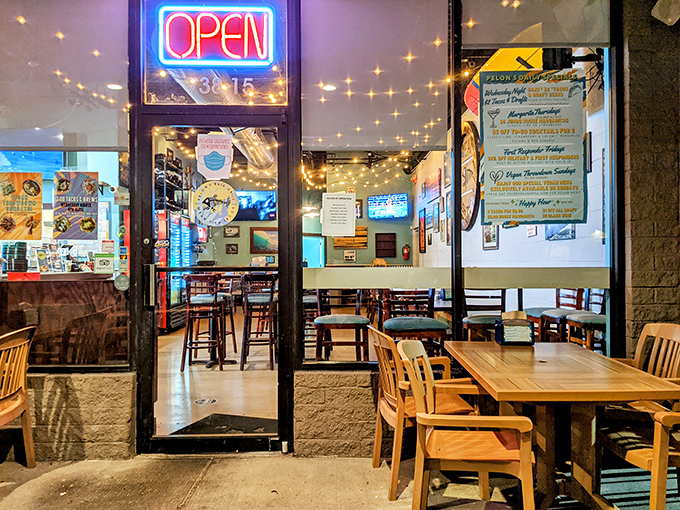 The neon "OPEN" sign might as well say "PARADISE" &ndash; peek through these doors and glimpse the warm, string-lit sanctuary of flavor waiting inside.