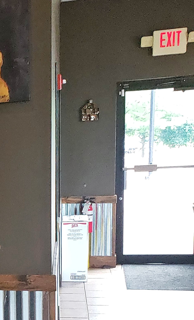 Even the exit sign glows with purpose, guiding satisfied customers back to a world where not all food is smoked to perfection.