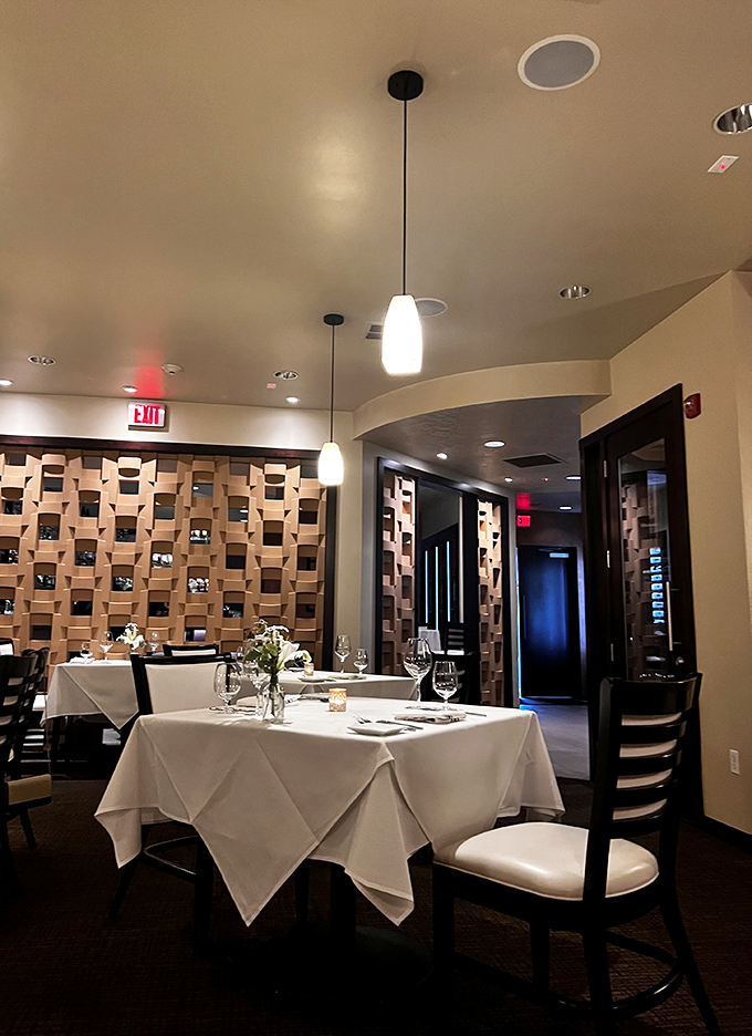 Modern elegance defines the dining room, where pendant lighting casts a flattering glow over white tablecloths and thoughtfully arranged tables.