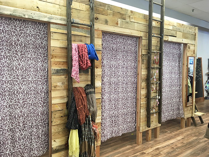 Fitting rooms with rustic charm and privacy curtains. The moment of truth in any thrifting adventure happens behind these wooden walls.