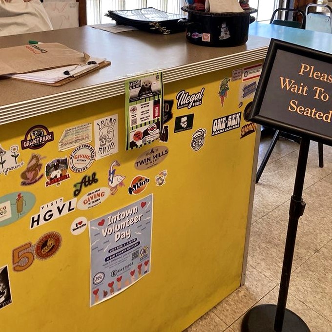 The sticker-covered host stand tells you everything: this place is loved, not by marketers, but by actual humans who eat here.