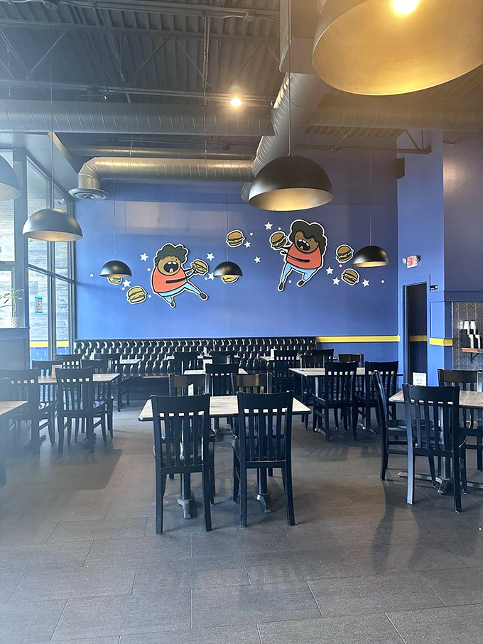 Whimsical burger characters dance across blue walls, celebrating what we're all thinking: these burgers are worth doing cartwheels for.