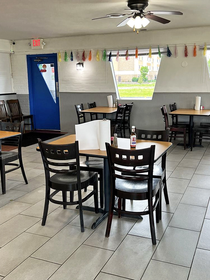 No-nonsense tables, practical chairs, and a blue door that might as well be a portal to comfort food heaven.