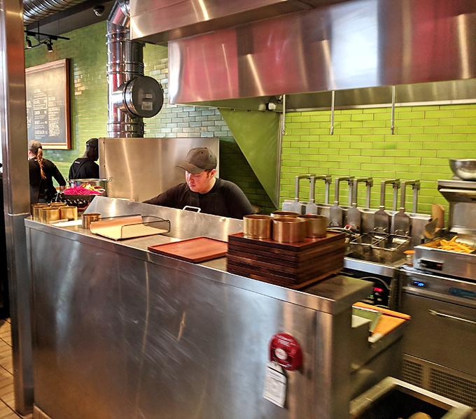The kitchen's lime green tiles provide a vibrant backdrop to the serious business of creating flavor bombs. Culinary magic in progress.