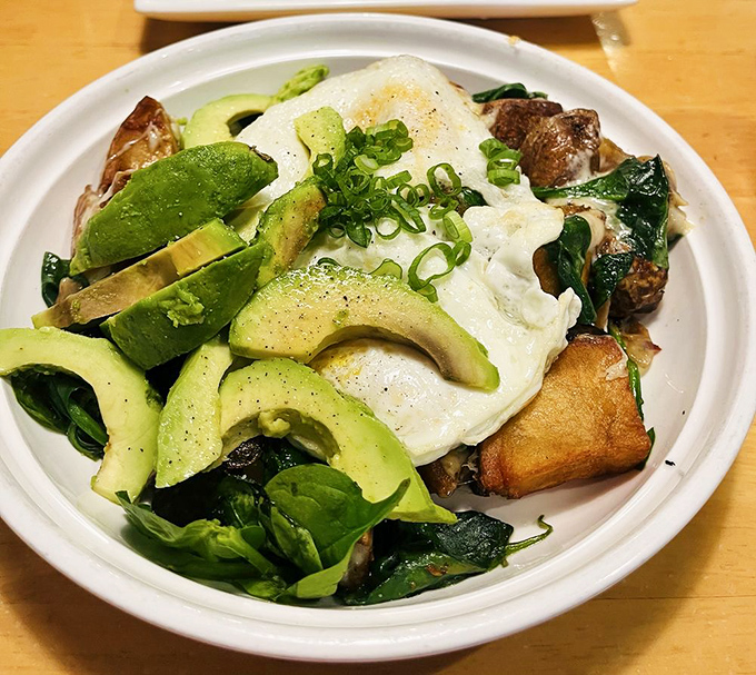 A breakfast bowl that's practically a work of art—avocado slices arranged like green petals around eggs that belong in a still-life painting.