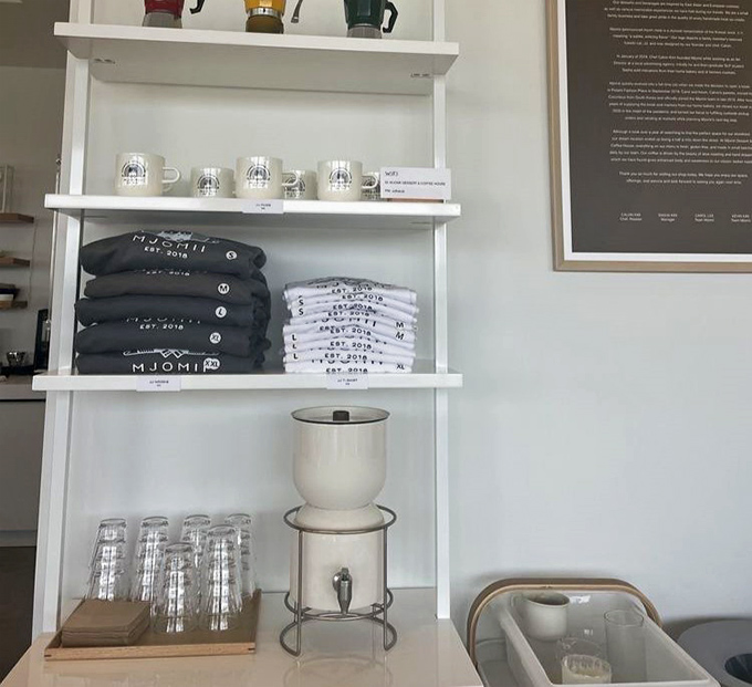 Even the merchandise display maintains the minimalist aesthetic. Those mugs aren't just vessels for coffee&mdash;they're souvenirs of sweetness.