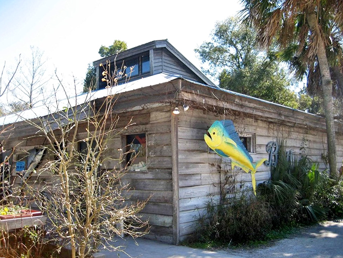 Colorful fish sculptures adorn the rustic exterior, like sentinels guarding the seafood treasures within. Florida charm in architectural form.
