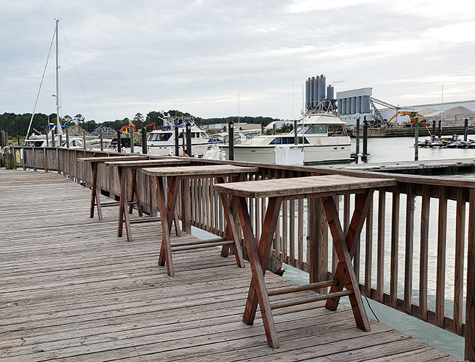 Weathered wooden high-tops along the deck&mdash;where strangers become friends over shared plates and harbor stories.