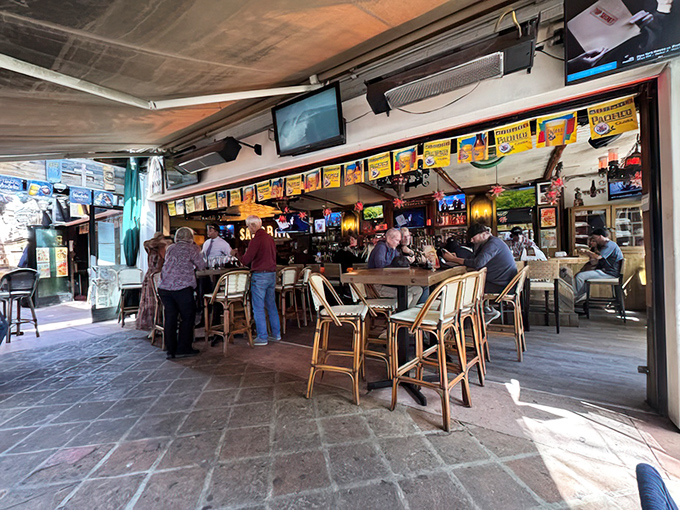 The outdoor bar where "just one more" becomes a mathematical impossibility. Those bistro chairs have supported countless happy hours and zero regrets.