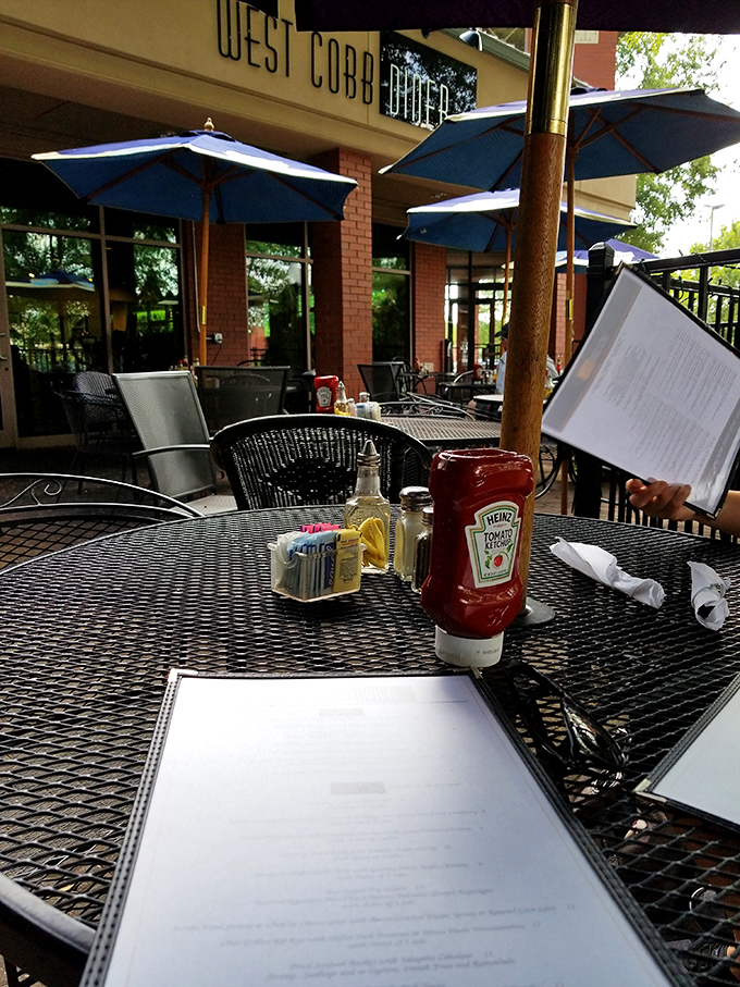 Outdoor dining under blue umbrellas offers a perfect spot for people-watching while enjoying Southern hospitality in the Georgia sunshine.