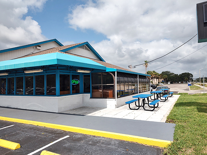 Outdoor seating with cheerful blue picnic tables offers the quintessential Florida dining experience&mdash;breakfast with a side of sunshine and gentle breezes.