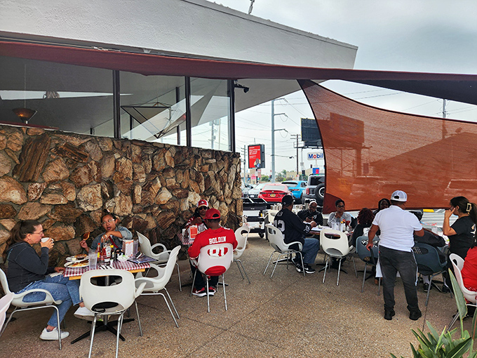 The outdoor patio, where the stone wall meets California sunshine, offering the perfect spot to watch planes approach LAX between bites.