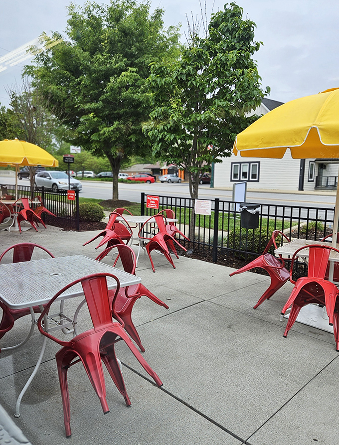 Red metal chairs and yellow umbrellas create an outdoor dining space that's both retro and timeless&mdash;like finding a 1950s postcard brought to life.