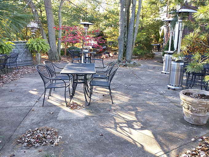 The outdoor seating area whispers promises of al fresco dining among the trees, where nature provides the perfect backdrop for culinary adventures.